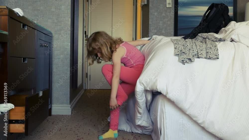 Vidéo Stock A little girl getting dressed adjusts her pant leg. Long ...