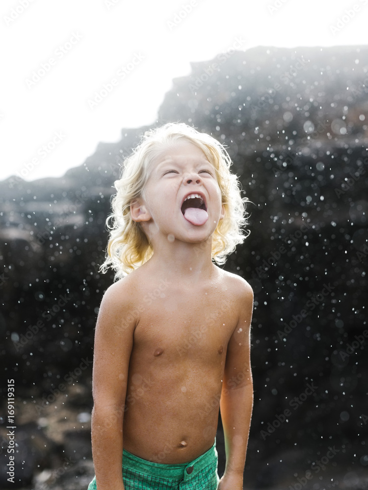 Shirtless boy playing with rain Stock Photo | Adobe Stock