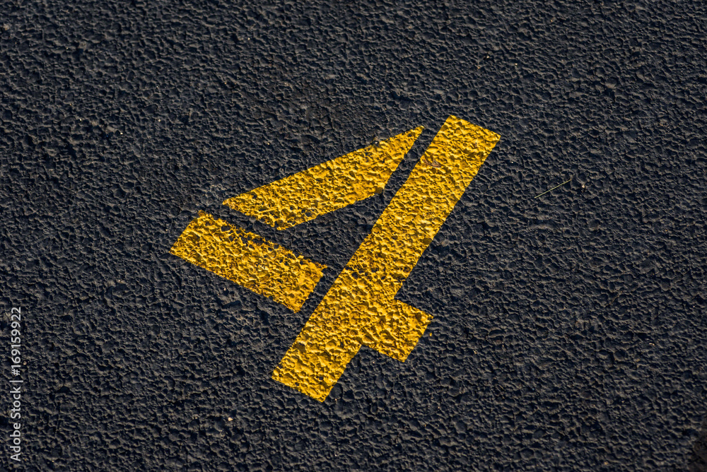 stenciled number 4 four in yellow paint on blacktop in parking lot ...