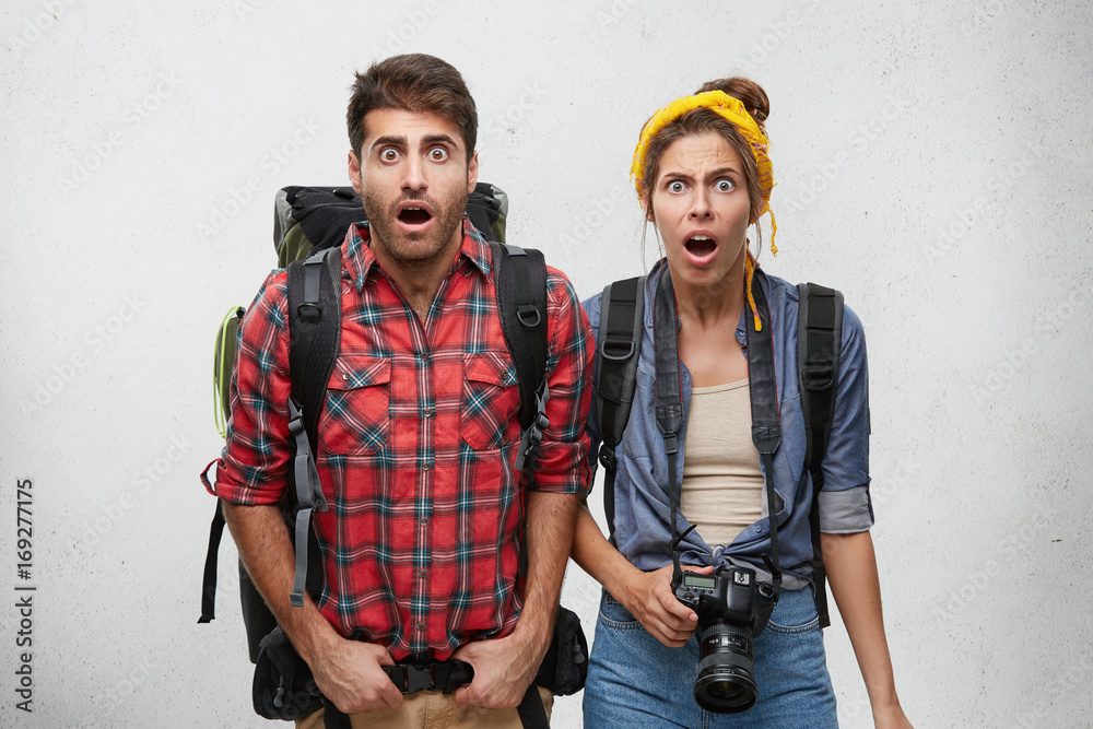 Picture of surprised hipsters make and female in casual clothes having ...