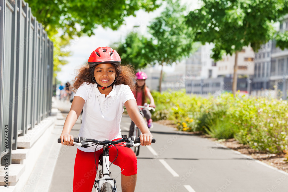 Happy African girl riding bicycle on cycle path Stock Photo | Adobe Stock