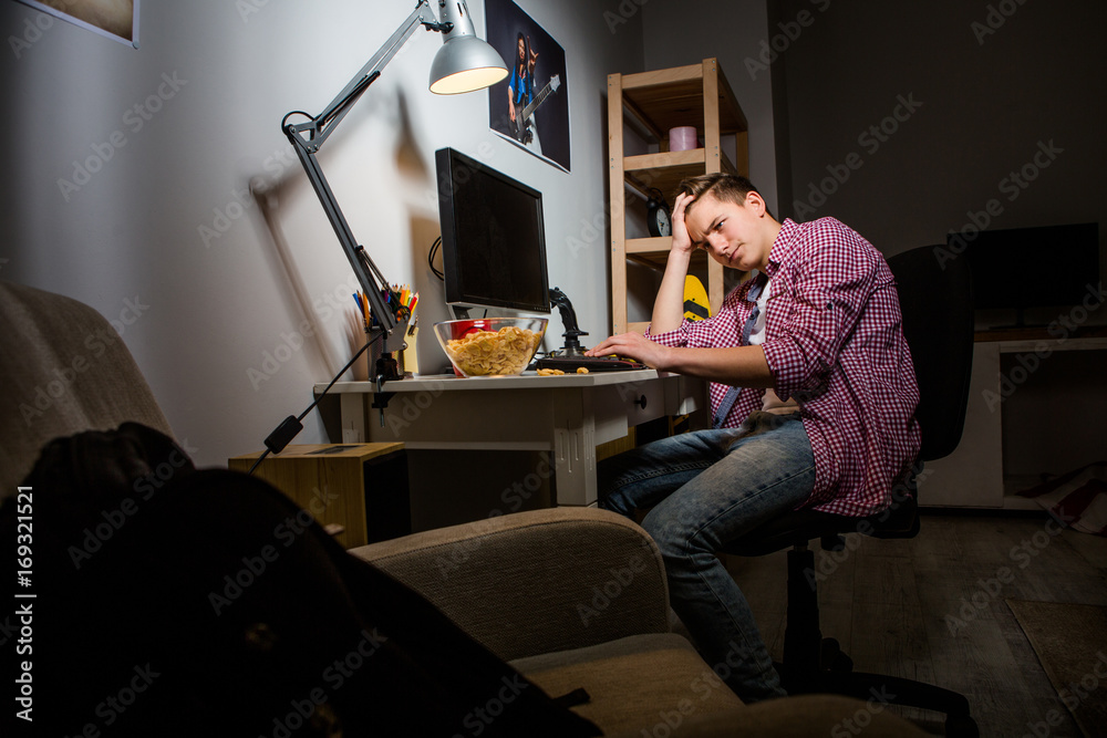 Sad teenage boy in his room in the night. Modern concept of ...