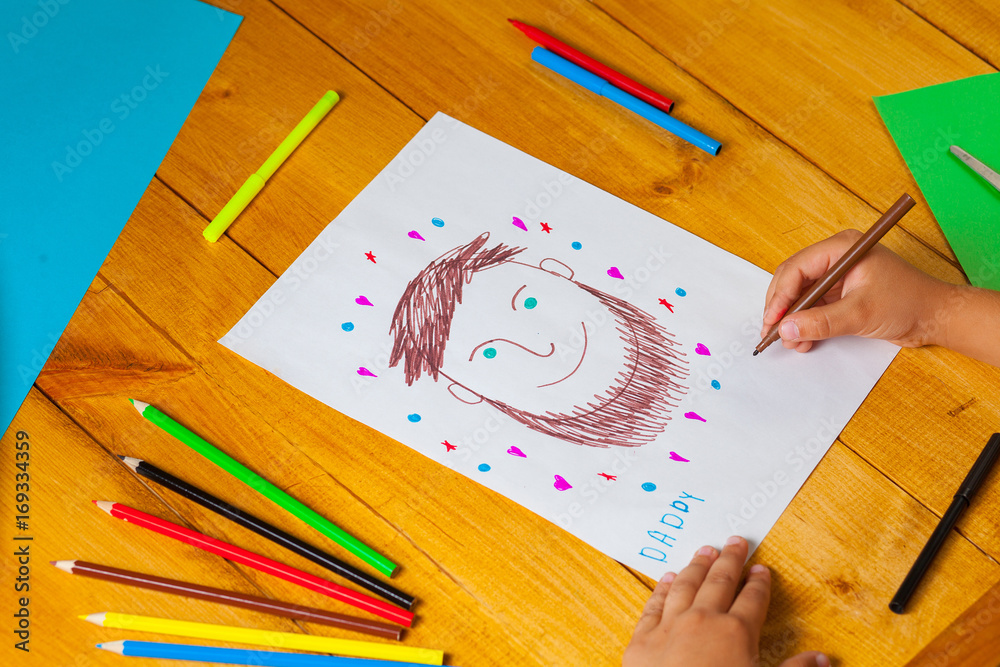 Child draws a portrait of his dad on father's day. The little boy did ...