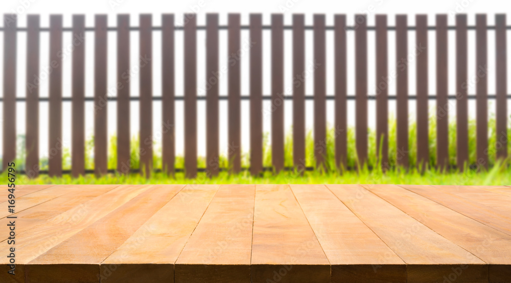 Wood table top with fence and grass in garden background.For create ...