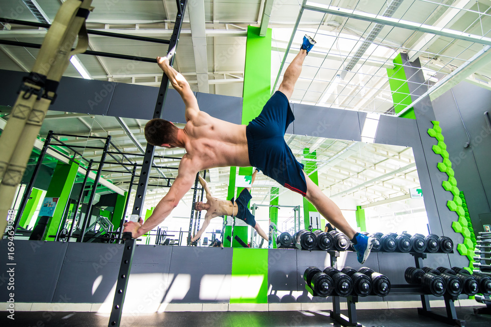 Fitness toes to bar man side pull-ups bars workout exercise at gym ...