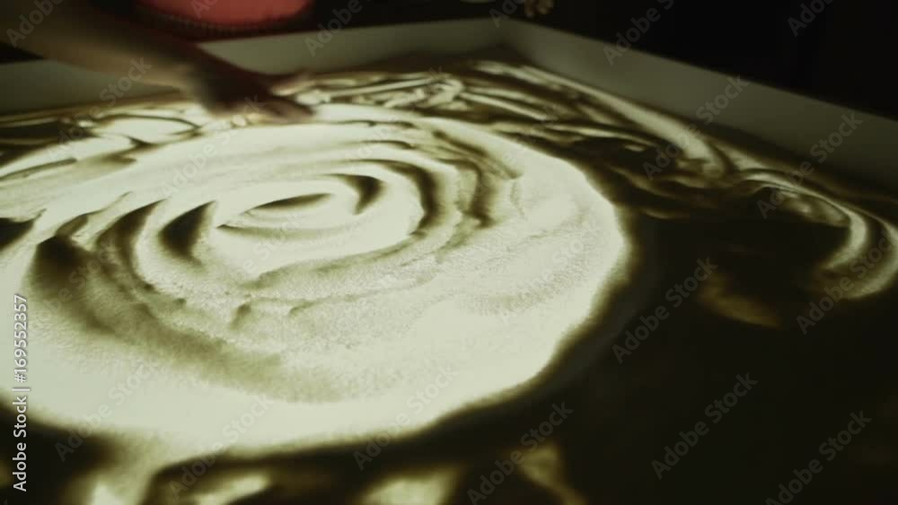 Drawing with sand. Short show. Drawing sand on a white screen. Sand ...