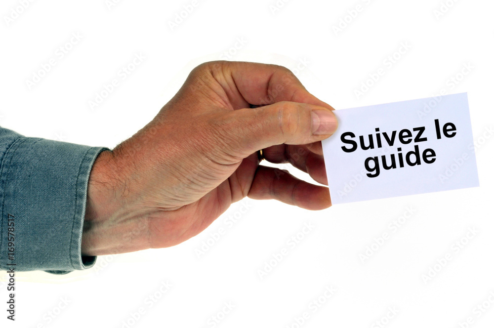 Main d'homme tenant une carte sur laquelle est écrit suivez le guide ...