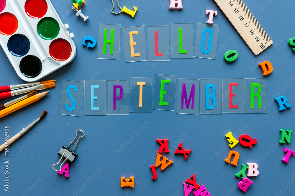 Hello September text on teacher or pupil table with school supplies ...