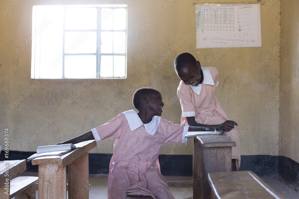 Smiling school girls sitting in the classroom Stock Photo | Adobe Stock