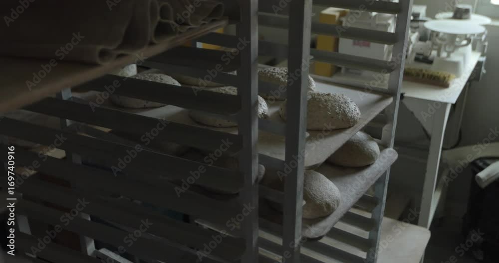 Bread dough loaves rise on racks in a craft bakery for baking later ...