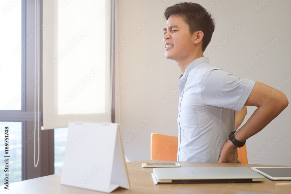 close up employee man stretching back after hard working,office ...