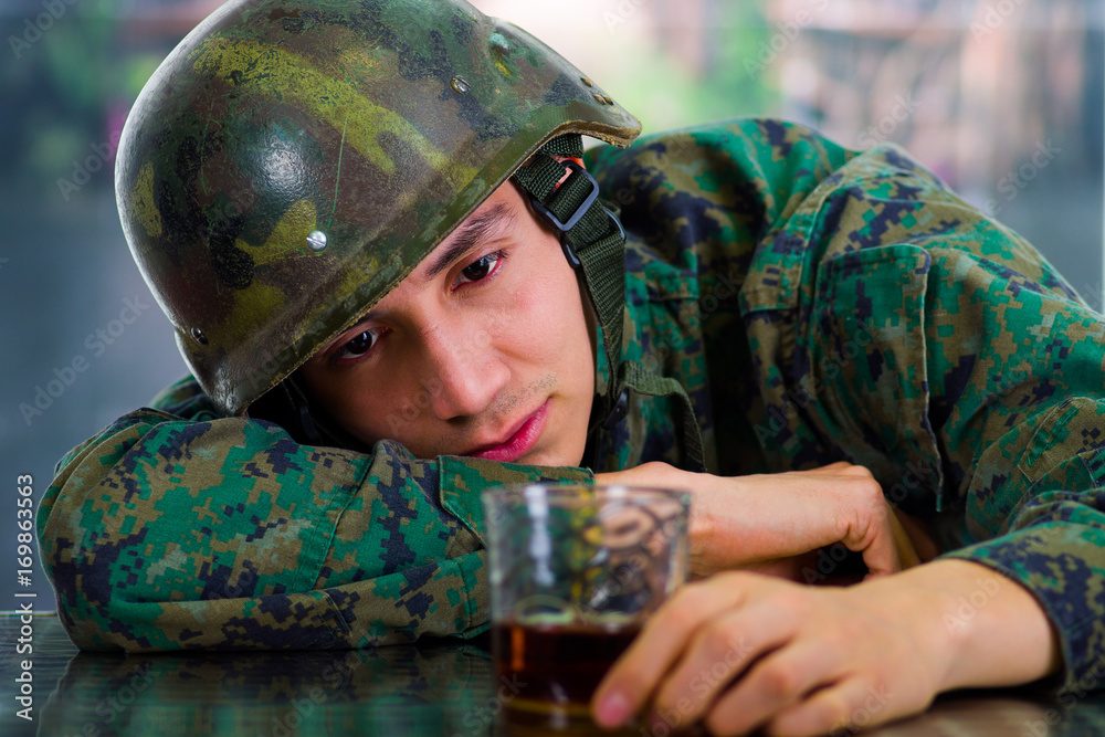 Handsome young soldier wearing uniform suffering from stress post-war ...