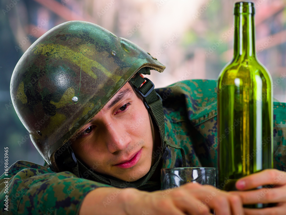 Handsome young soldier wearing uniform suffering from stress post-war ...