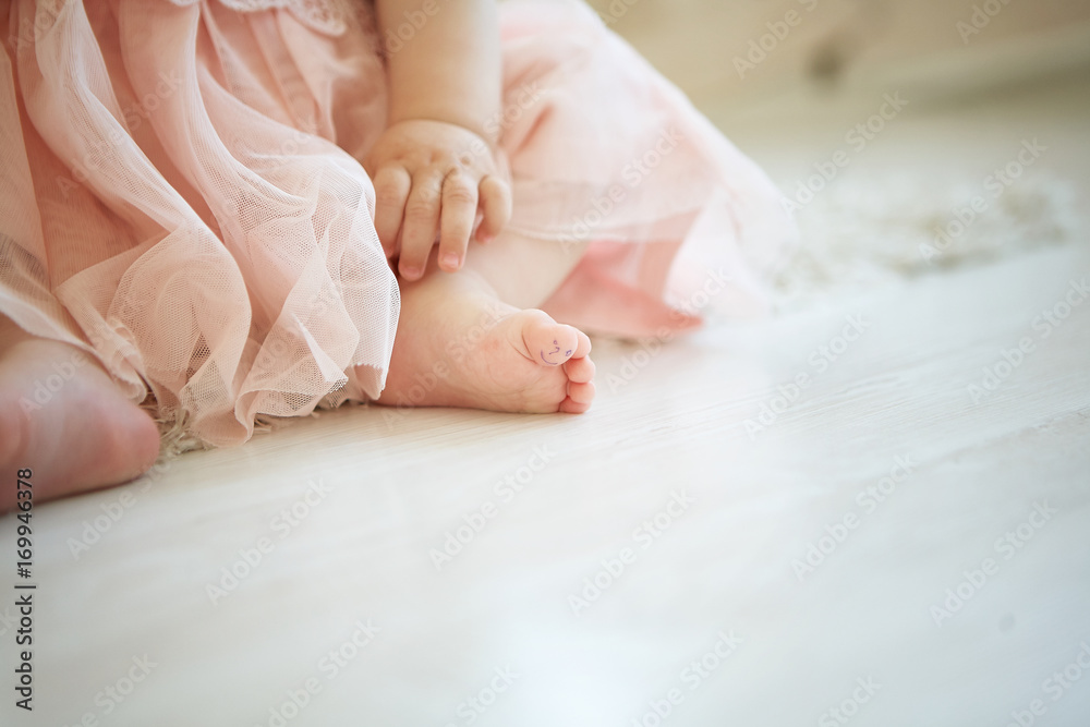little baby on the floor with drawn smiley face on her big toe Stock ...
