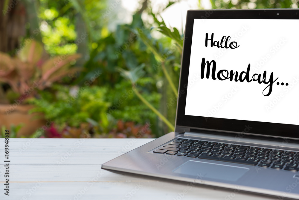 Monday text wrote on screen laptop over wood table with green garden ...