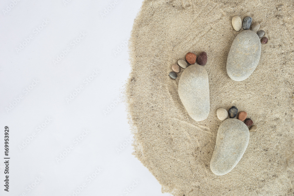 Group of pebble stones on sand creating de form of a foot in isolated ...