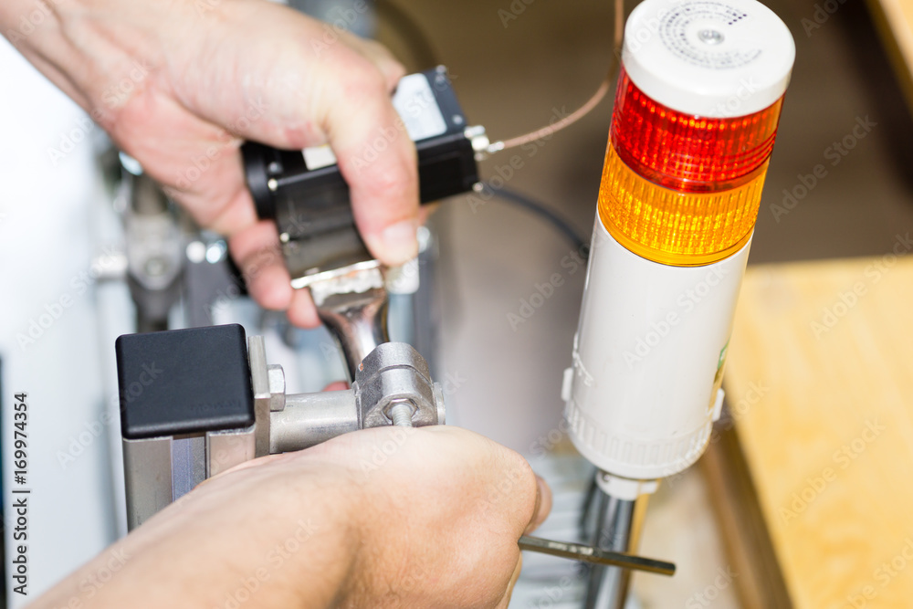 Engineer hands installing robotic machine vision system in factory ...