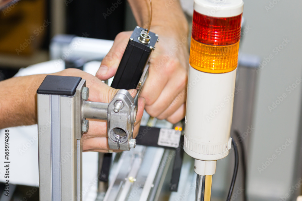 Engineer hands installing robotic machine vision system in factory ...
