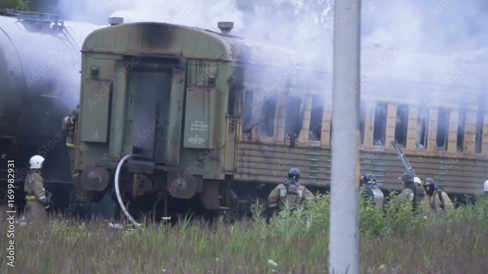 Fire at railway station. Firefighters extinguish railway car. Firemen ...