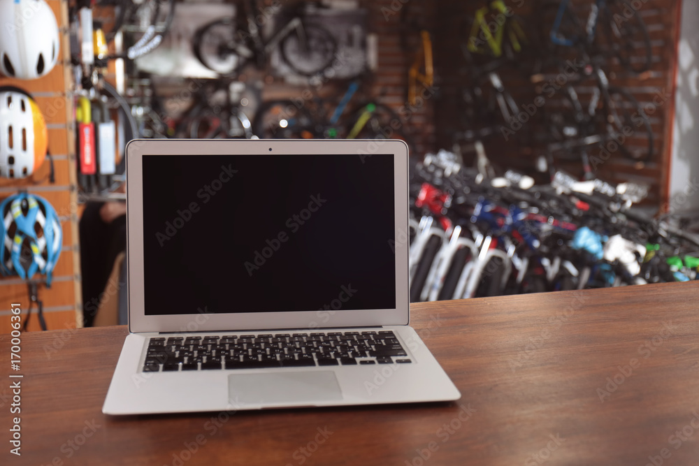 Counter with modern laptop in bicycle shop Stock Photo | Adobe Stock