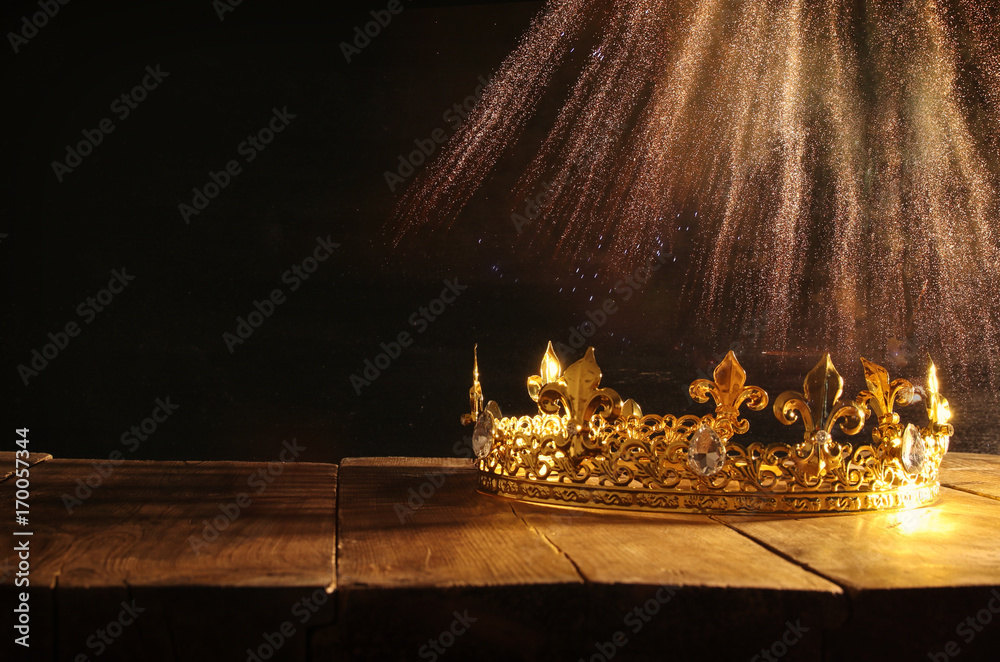 low key of beautiful queen/king crown over wooden table. vintage ...