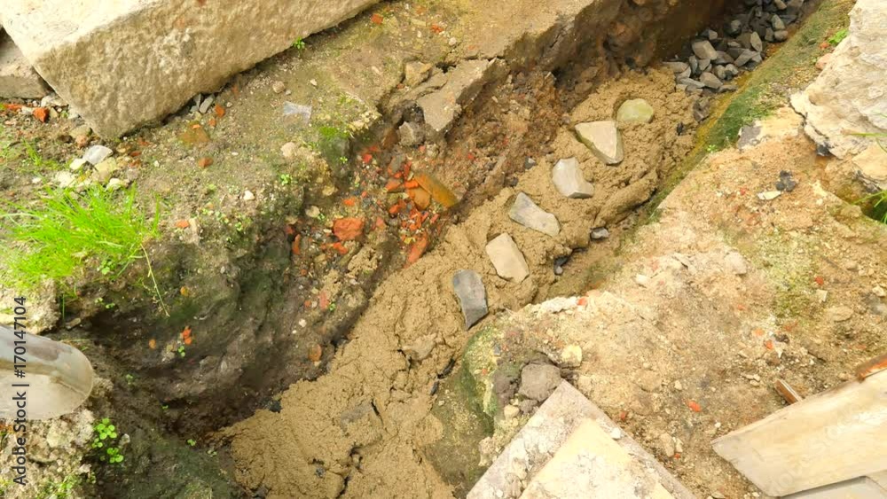 Pouring, laying concrete into foundations of the house using shovel of ...