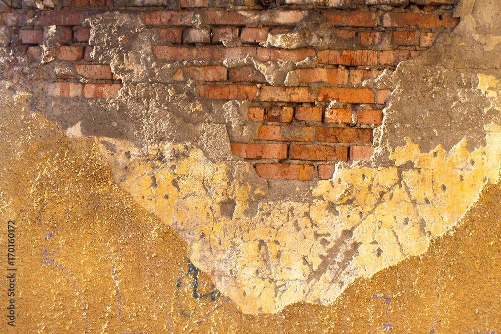 Wall from a red brick with destroyed plaster. Traces from bullets ...