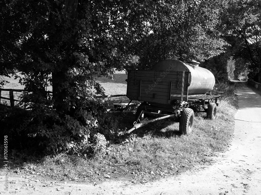 Anhänger mit Wassertank im Schatten neben einer Viehweide am Barkhauser ...