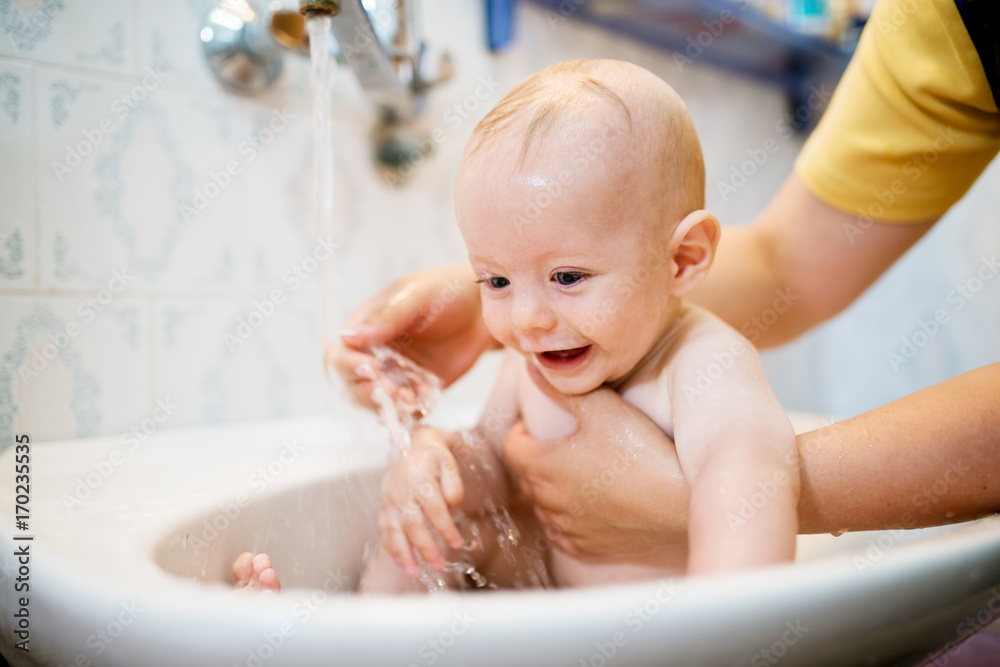 Happy laughing baby taking a bath. Little child in a bathtub. Smiling ...