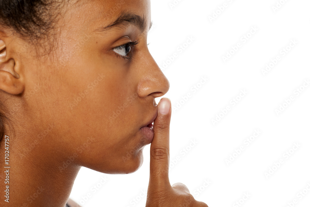 profile of beautiful dark skinned girl making gesture for silence on ...