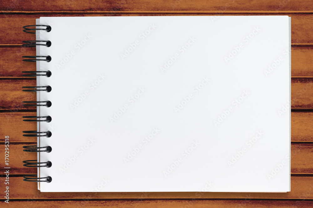 Blank notebook page on top of wood office desk table. Top view, flat ...