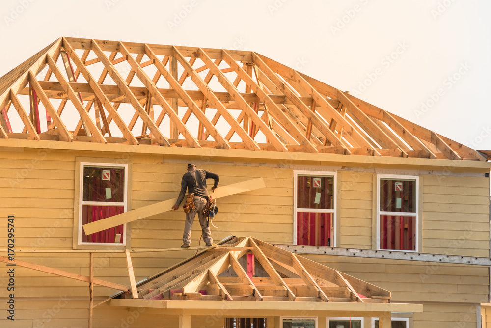 Rear view of builder at eco wooden house construction site near ...