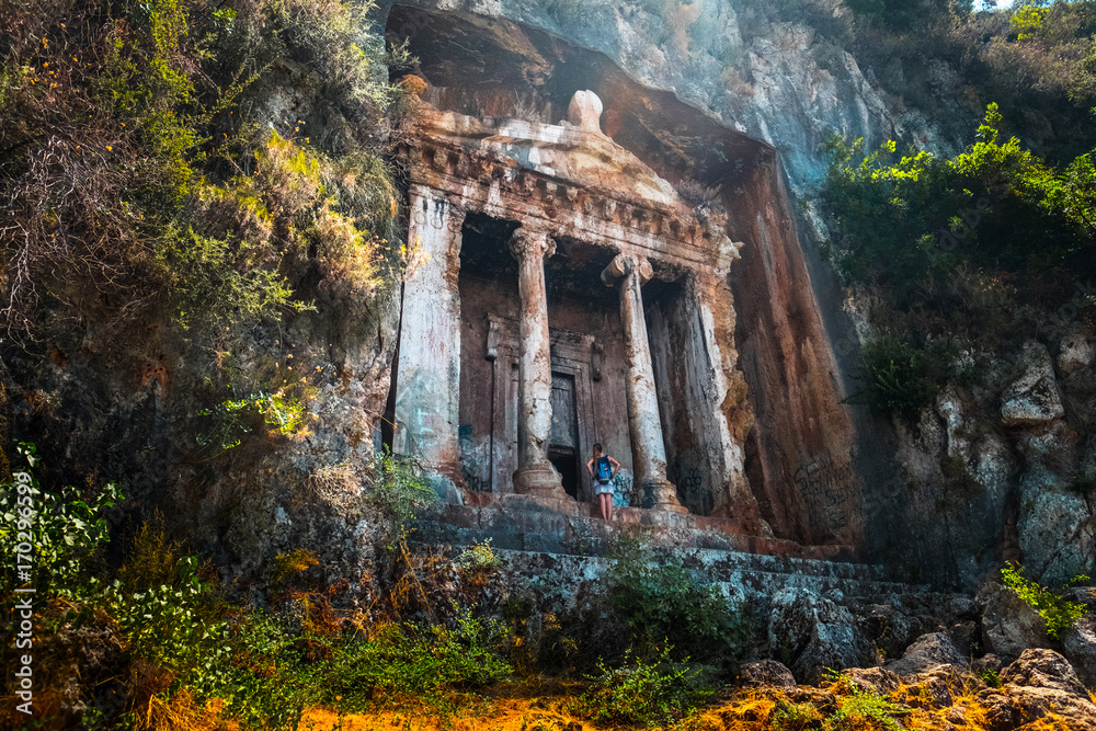 Amyntas rock tombs - 4th BC tombs carved in steep cliff. Tourist stands ...