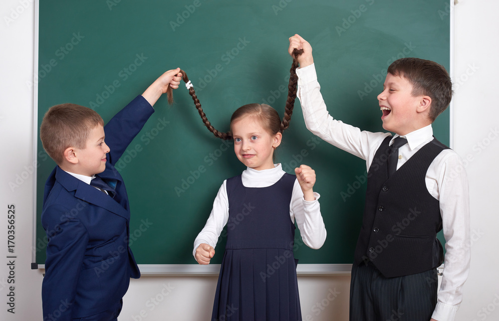 child play and having fun, boys pull the girl braids, near blank school ...