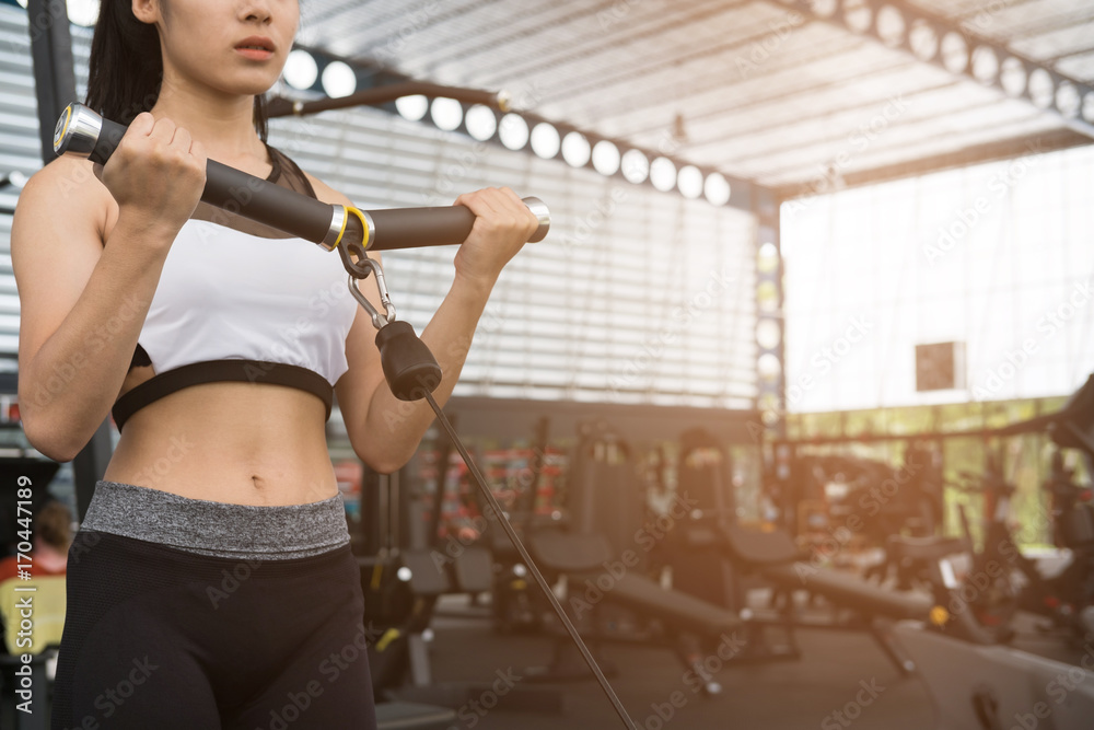 young woman execute exercise with machine in fitness center. female ...