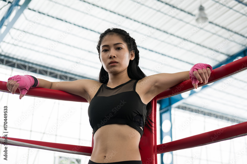 young woman prepare for exercise in fitness center. female boxer posing ...