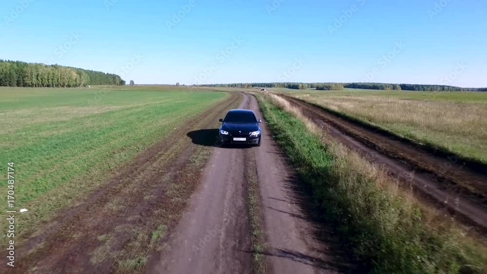 The car on the nature. Fotage. Black car driving on rural road. Aerial ...