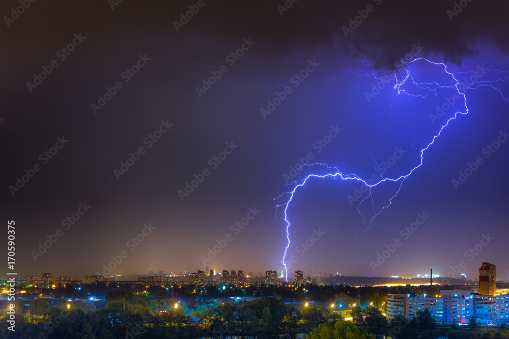 Lightning over the city at the summer storm. Dramatic, breathtaking ...