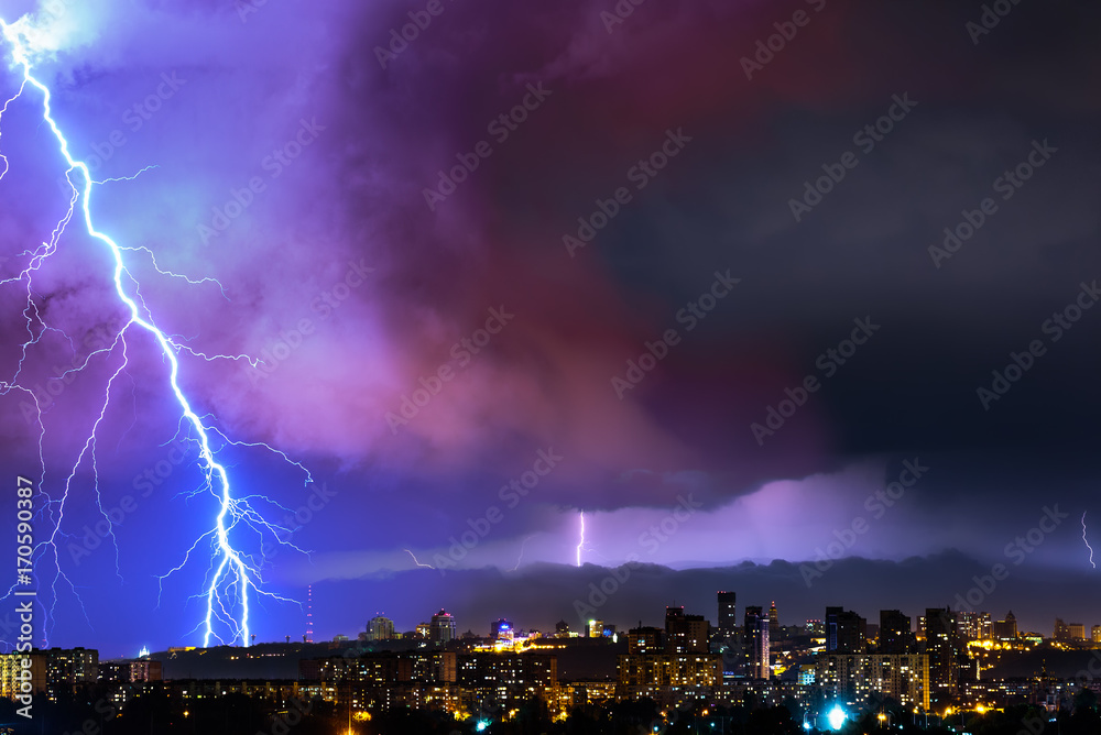 Lightning over the city at the summer storm. Dramatic, breathtaking ...