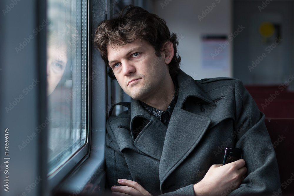 Traveling by train. Sad man traveling by train, looking through the ...