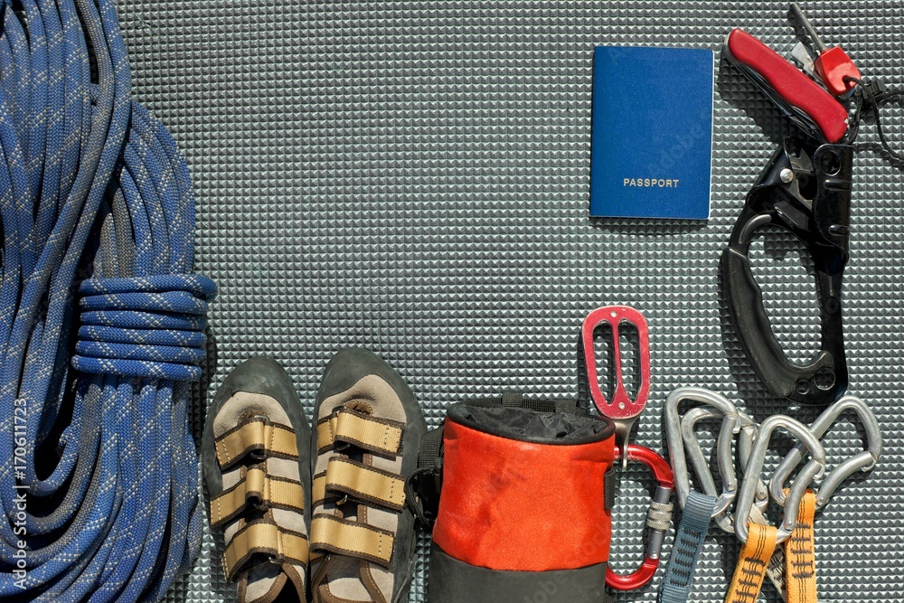 Top view of climbing equipment laid out beautifully on a grey mat. Rope ...