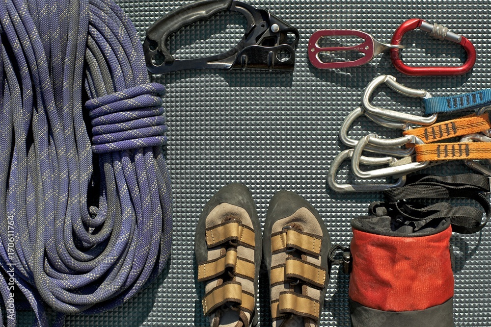 Rock climbing gear laid out beautifully on a grey mat. Rope, ascender ...