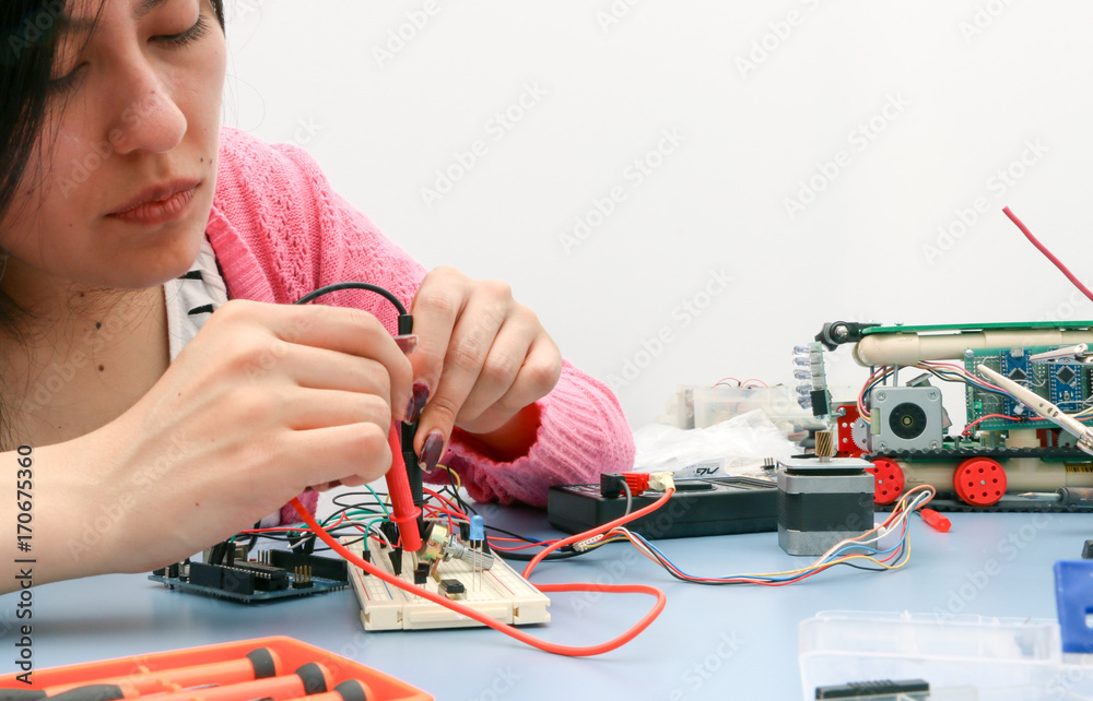 Young electronics student learning about basic PCB connection and ...