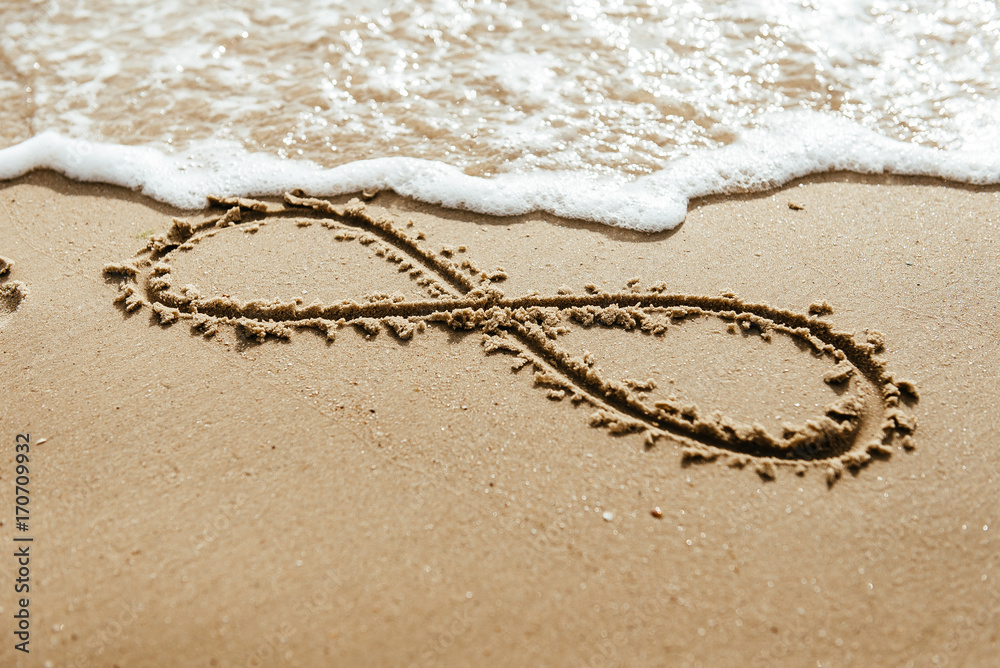 infinity symbol written on Sand on the beach, ocean Stock Photo | Adobe ...