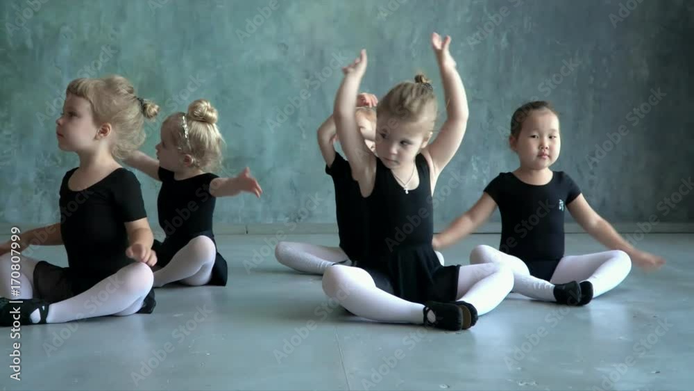 Beautiful and stately ballet teacher in the classroom teaches children ...