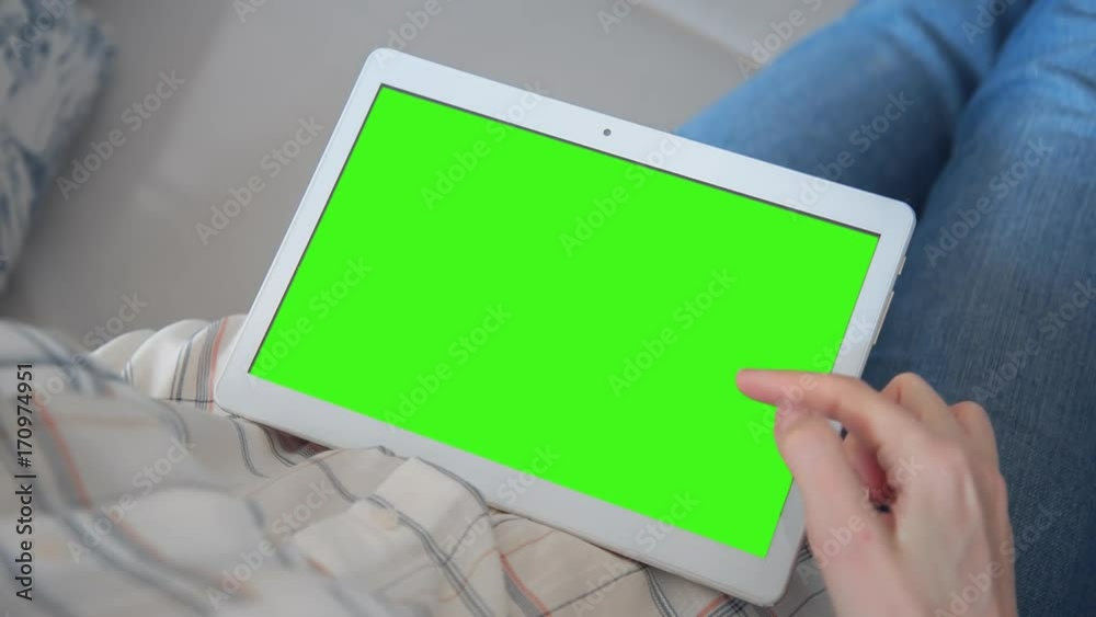 Vidéo Stock Young Woman in blue jeans laying on sofa uses Tablet PC ...