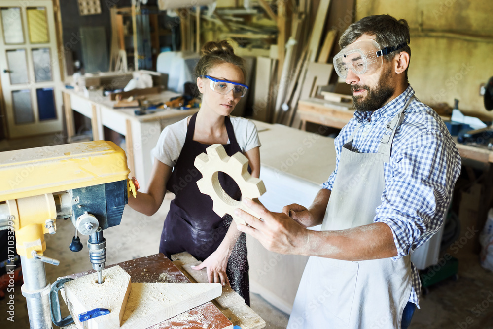 Group of hard-working carpenters looking at just finished wooden detail ...