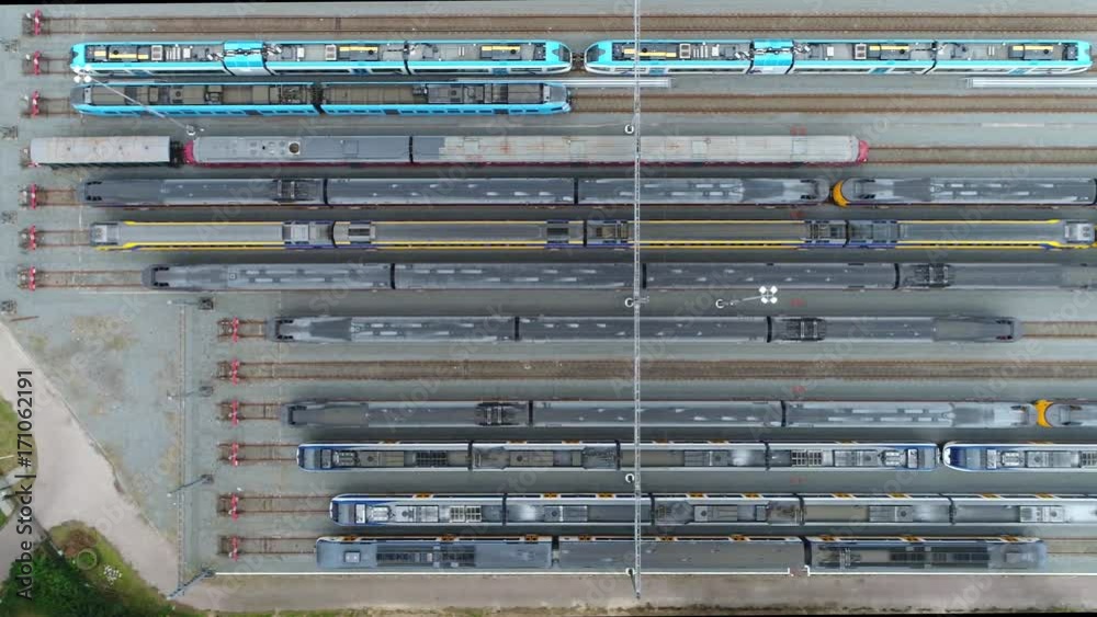 Aerial moving right above railway hub showing passenger trains on ...