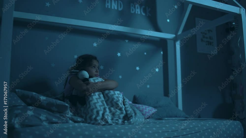 Little scared girl sitting in her bed at night Stock Video | Adobe Stock