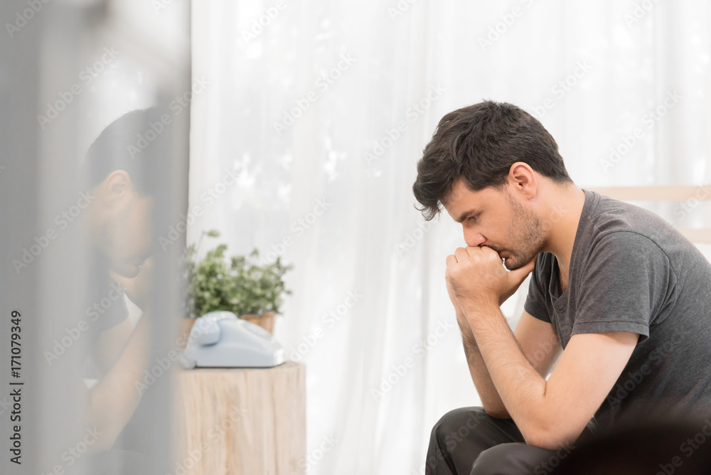Stressed and Sad Handsome man sitting on the bed. Disappointment ...